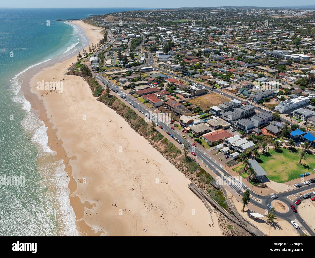 Aerial view of a coastal town and waterfront above a wide sandy beach ...