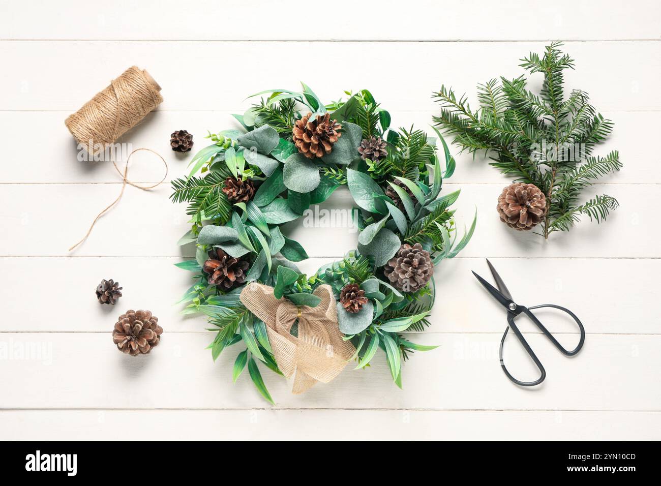 Beautiful Christmas mistletoe wreath with bumps and supplies on white ...