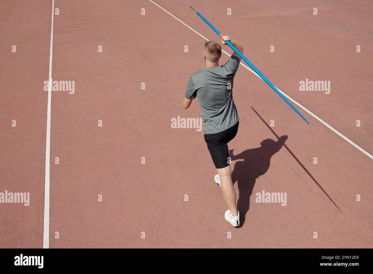 Javelin throw athlete preparing for a practice run on track field ...