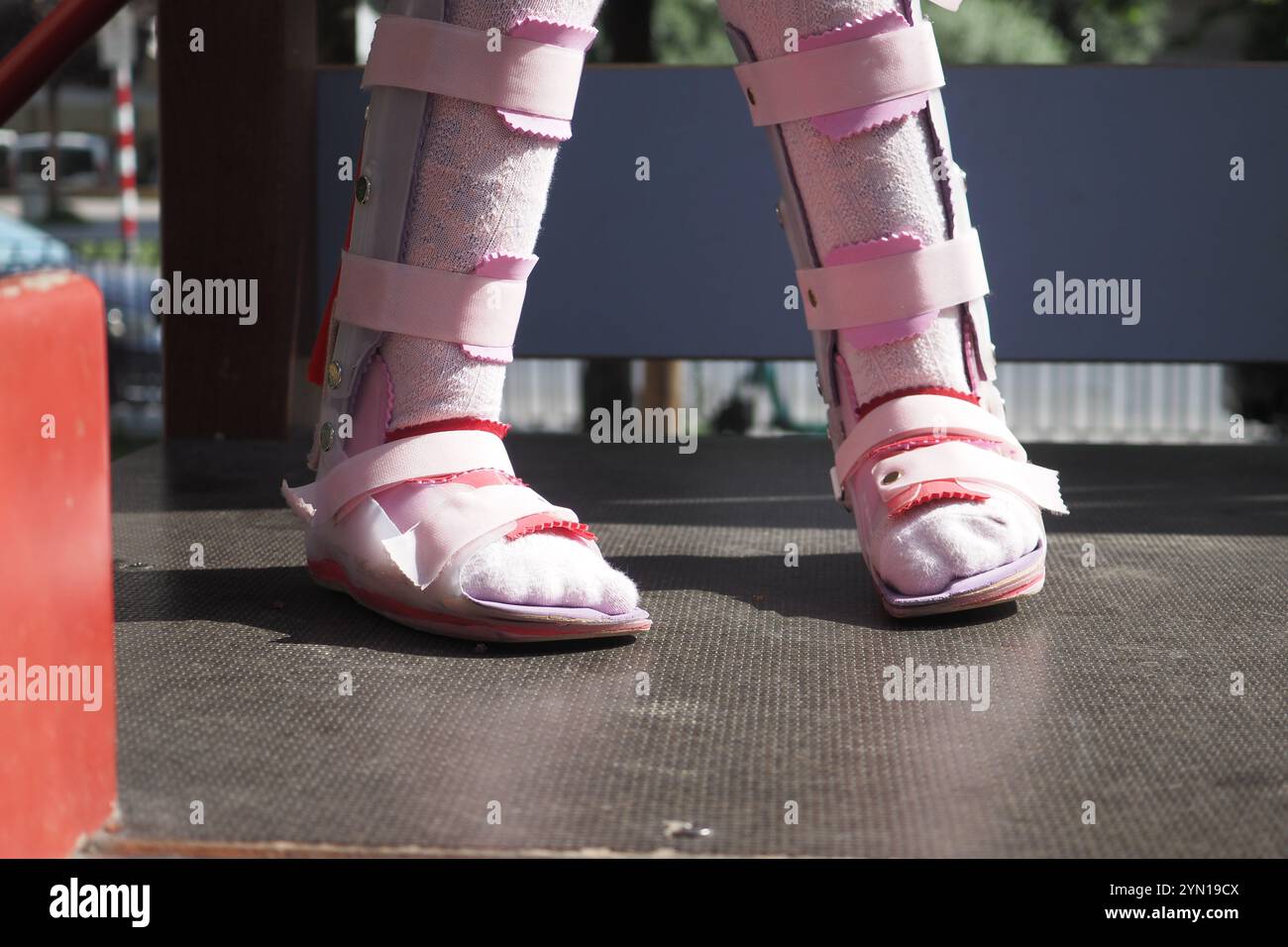 Child Walking With Leg Braces on Playground Surface Stock Photo - Alamy