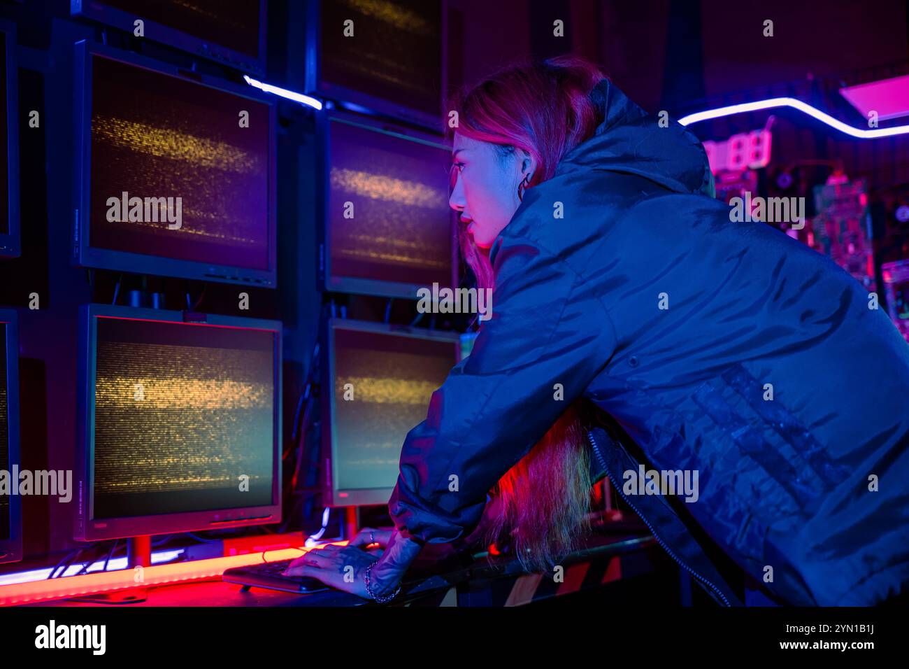 Asian woman wearing a black jacket hacking programming system and ...