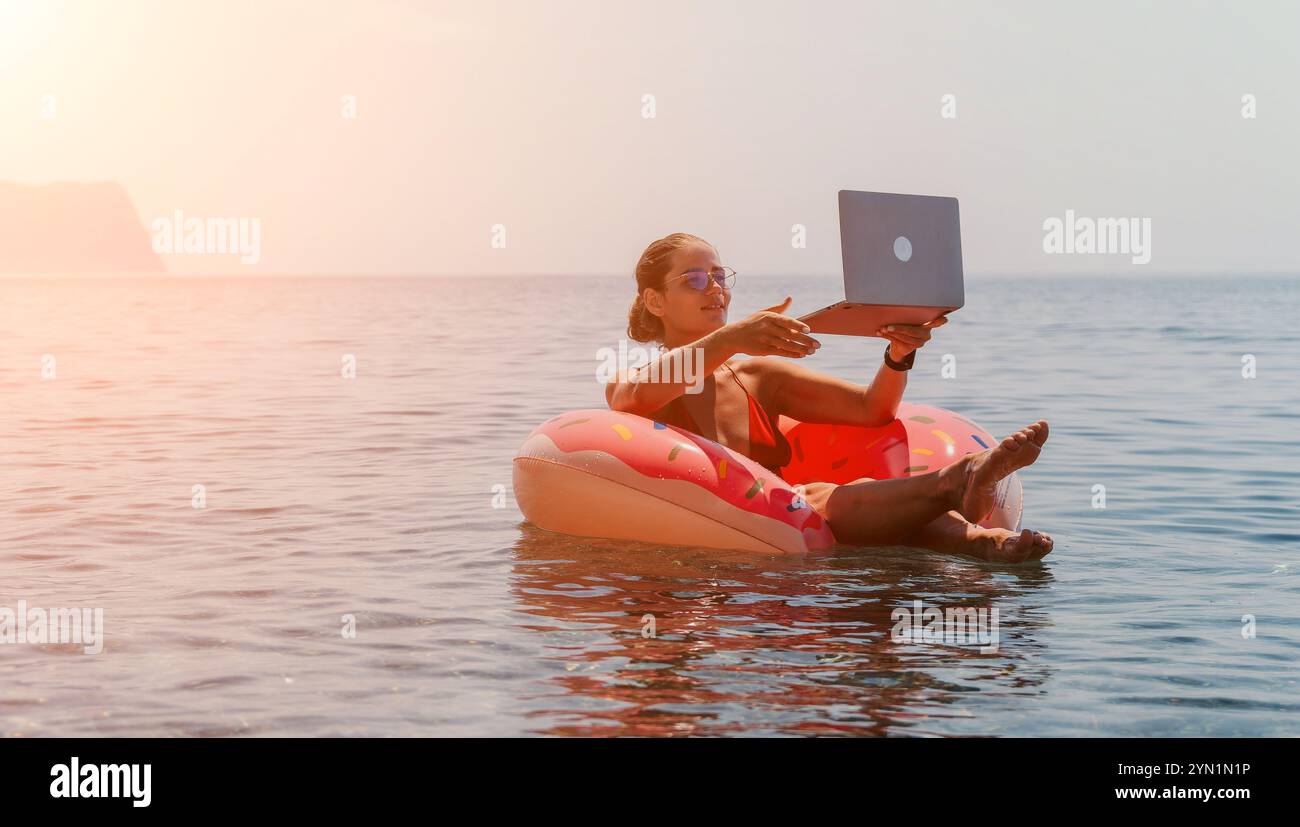 Laptop Beach Work: Woman working on a laptop while floating on an ...