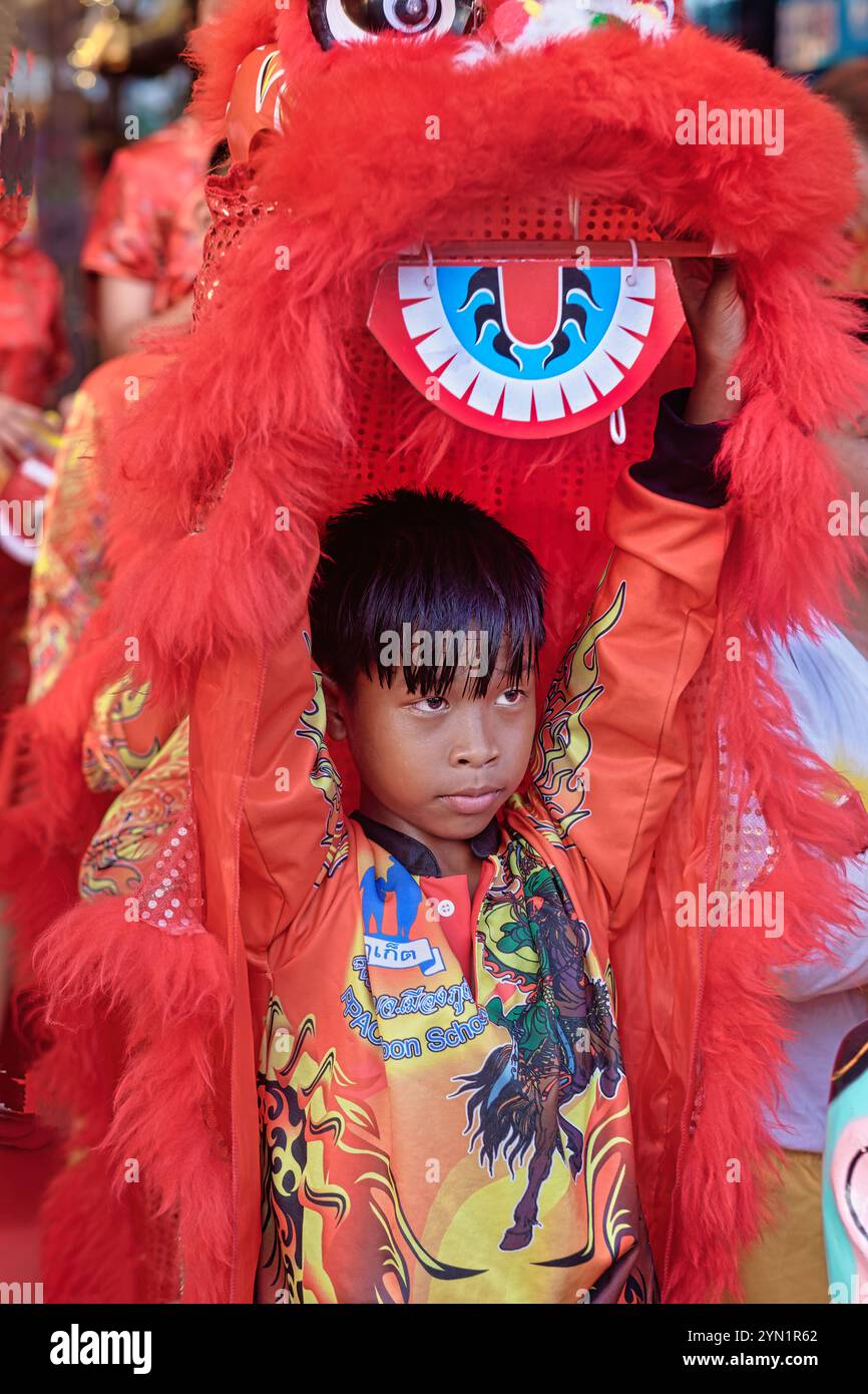A young Thai boy, a member of a lion dance troupe performing on ...
