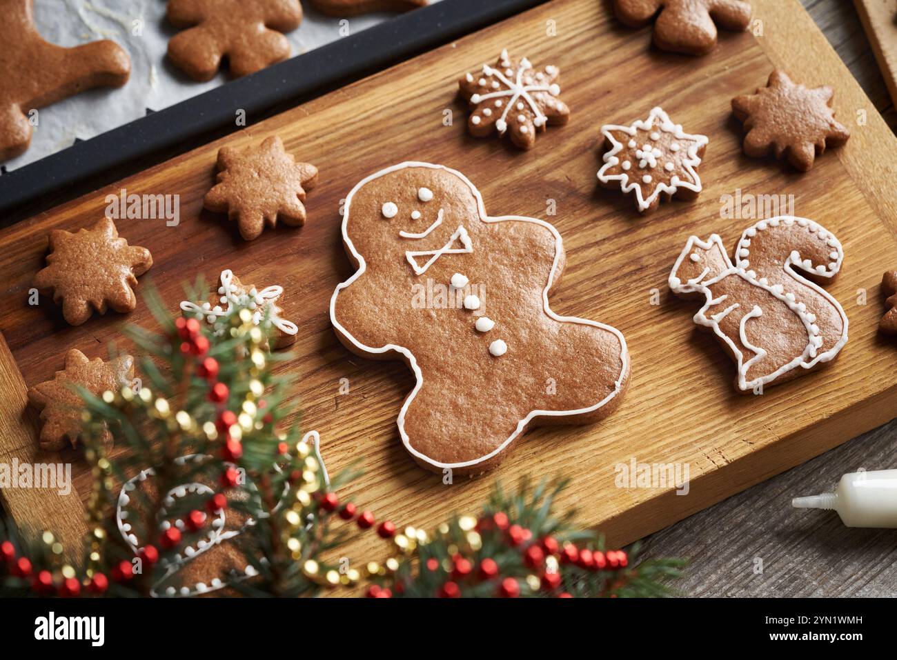Decorating man and animal shaped gingerbread Christmas cookies with ...