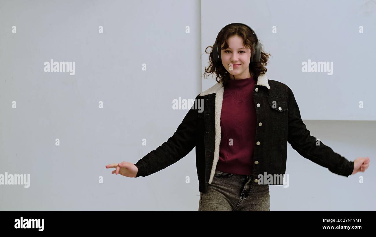 A relaxed child with headphones dances joyfully in a modern setting ...