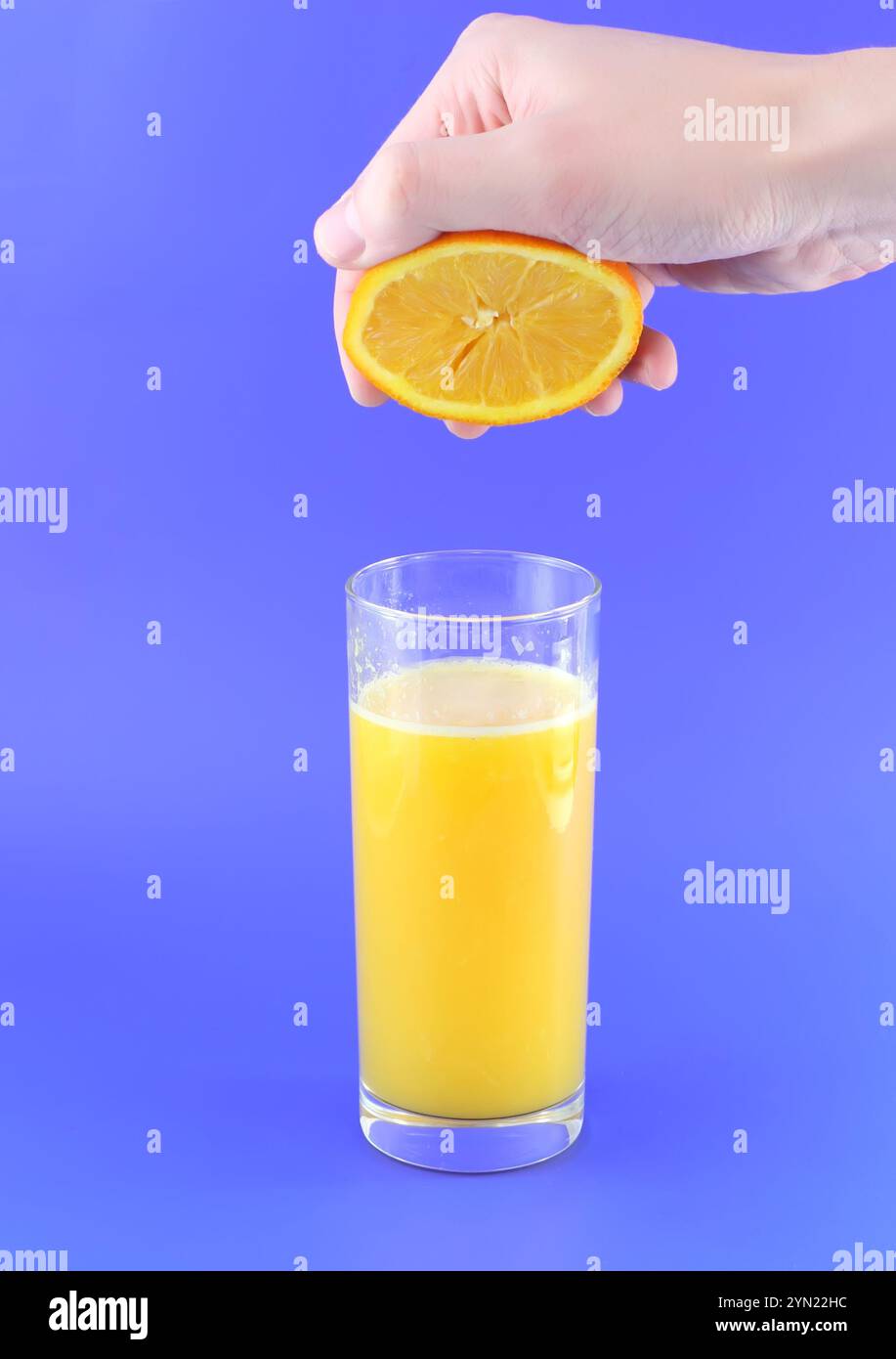 Glass of orange juice with hand, squeeze of orange Stock Photo - Alamy