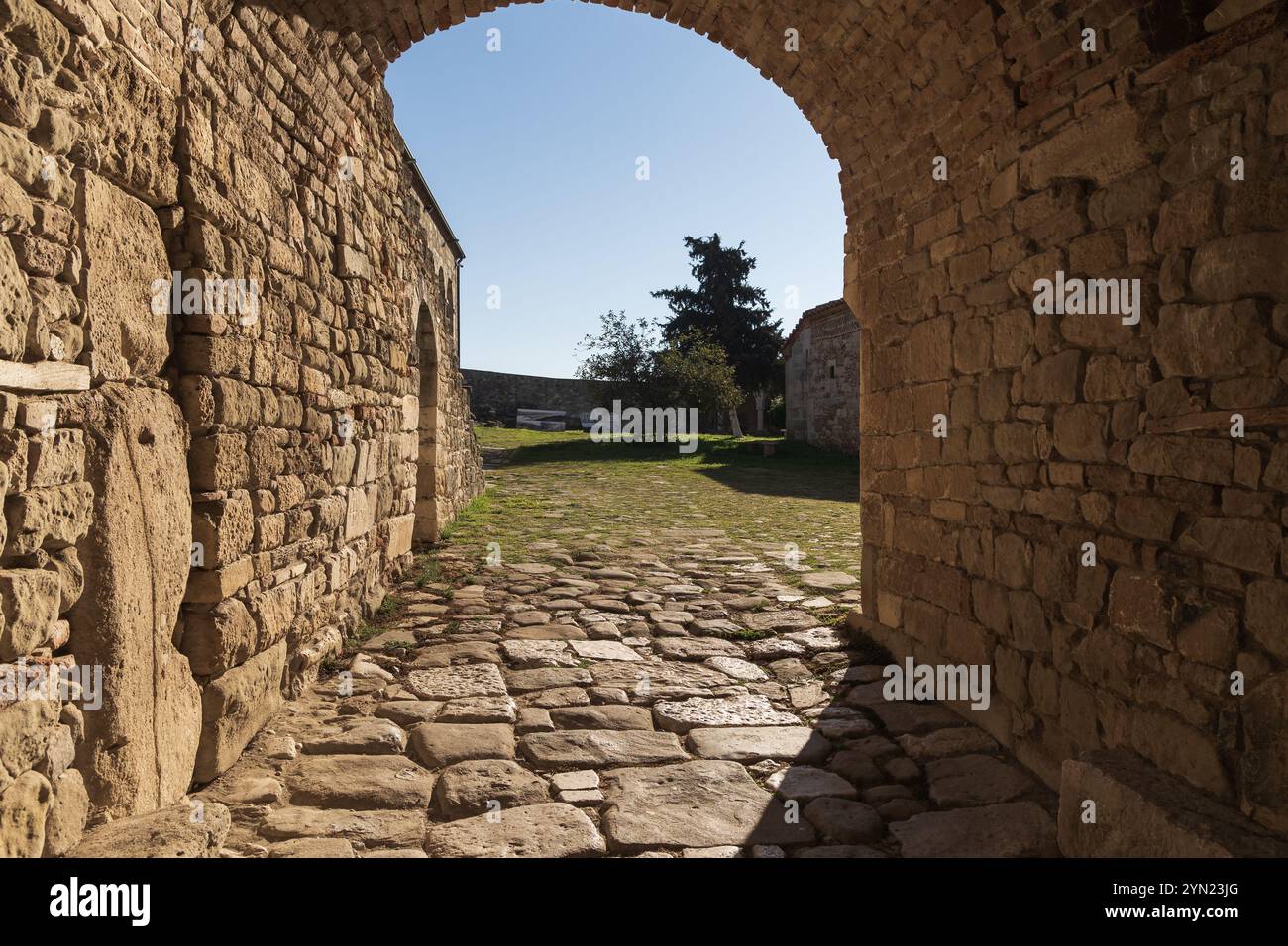 Archway of old medieval limestone wall texture with cobalt walk way ...