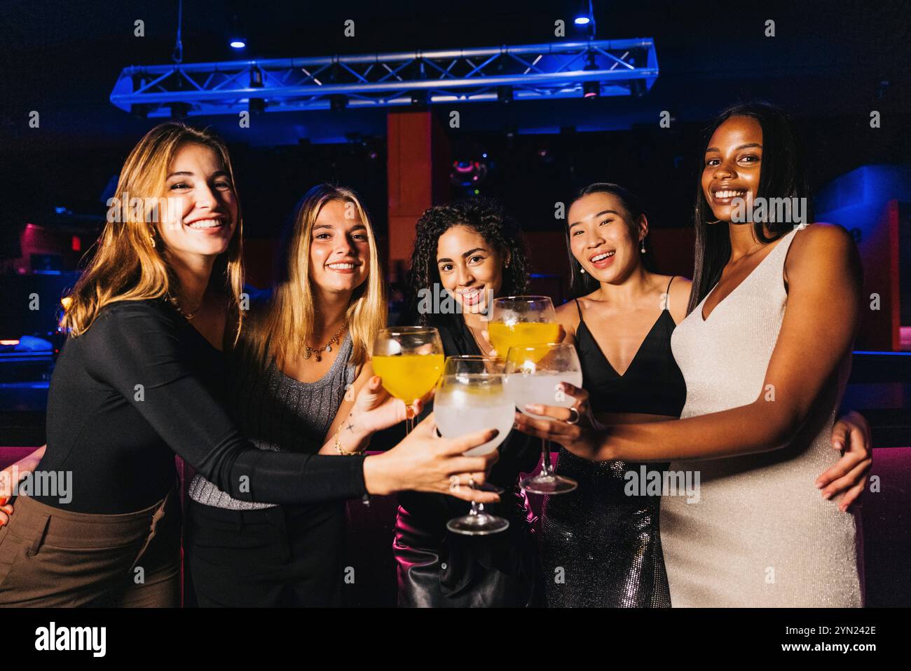 Group picture of joyful friends enjoying cocktails and smiling brightly ...