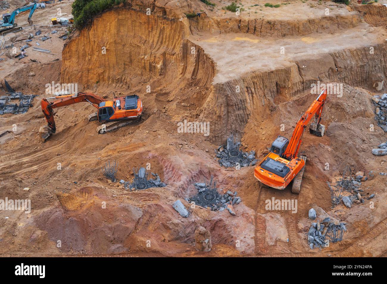 Excavators dig ground in the foundation pit of building on a ...