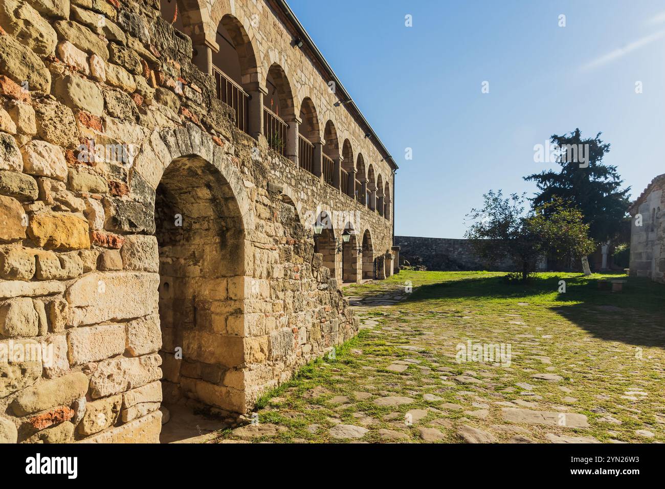 Old medieval limestone wall textured building with cobble stone walk ...