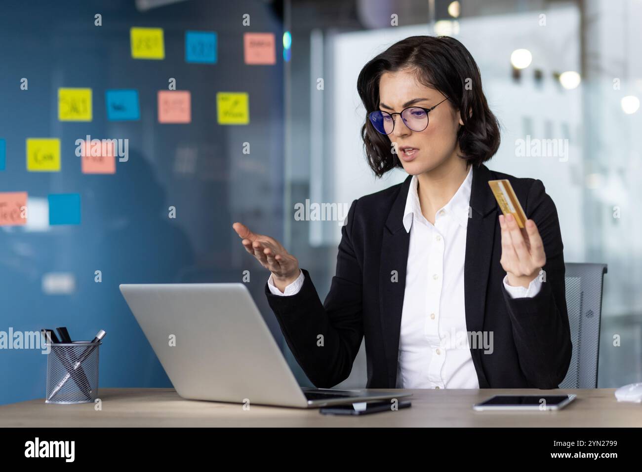 Businesswoman in office frustrated with credit card payment on laptop ...