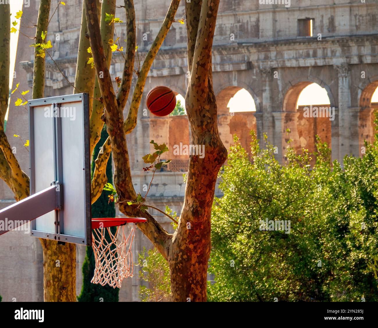 A basketball captured mid-air as it descends into the hoop on the court ...