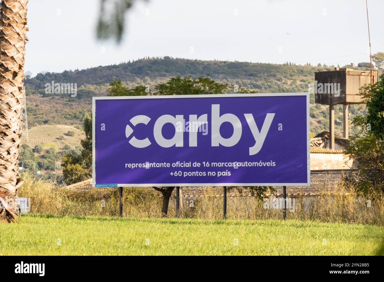 Large purple carby billboard advertising sixteen car brands and over ...