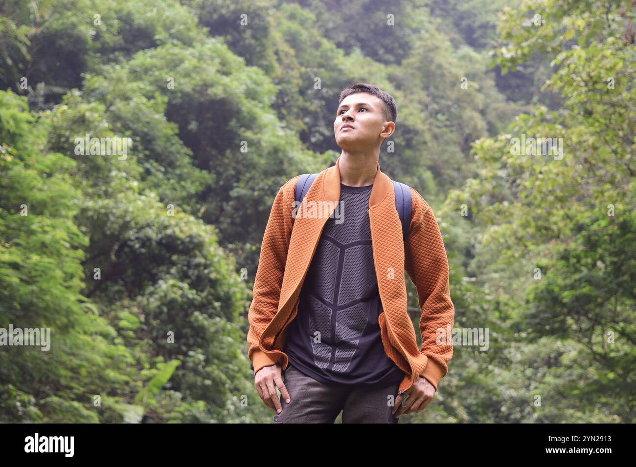 Portrait of Asian young male backpacker travelling in the middle of ...