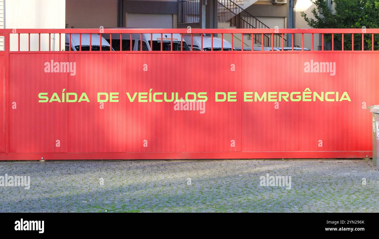 Red sliding gate with the portuguese inscription saida de veiculos de ...