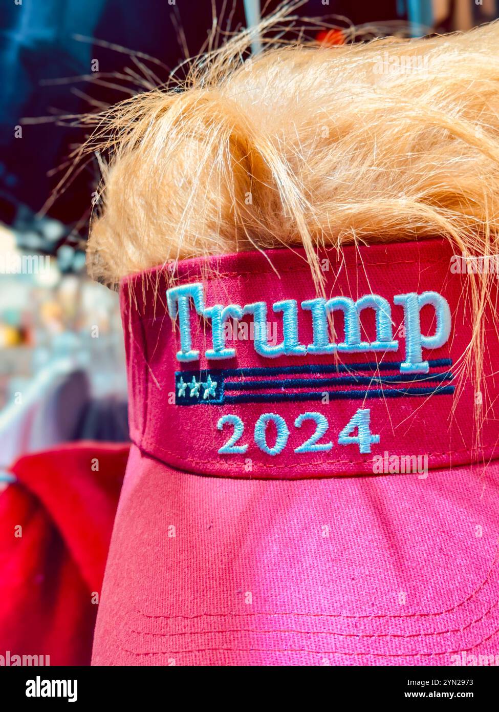 A “Make America Great Again” (MAGA) red baseball cap with a yellow wig ...