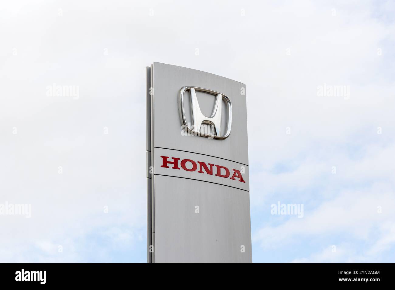 Honda dealership sign displaying the iconic logo against a backdrop of ...