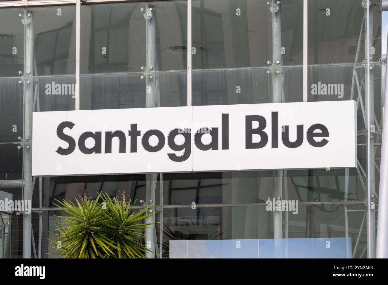 Santogal blue signage is attached to a modern glass building, possibly ...