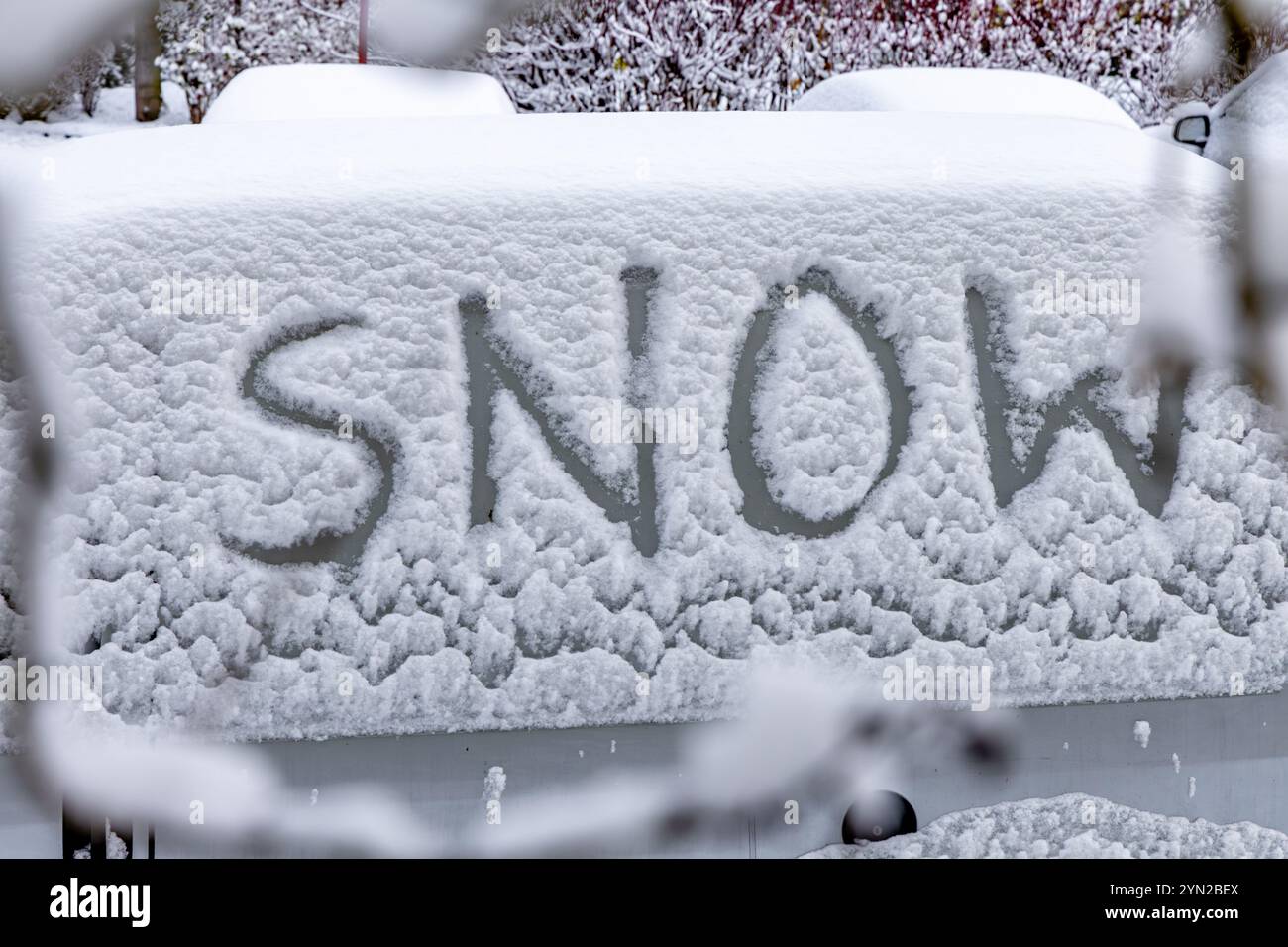 The attack of winter, the first snowfall, the word snow written on the car body in the snow ...