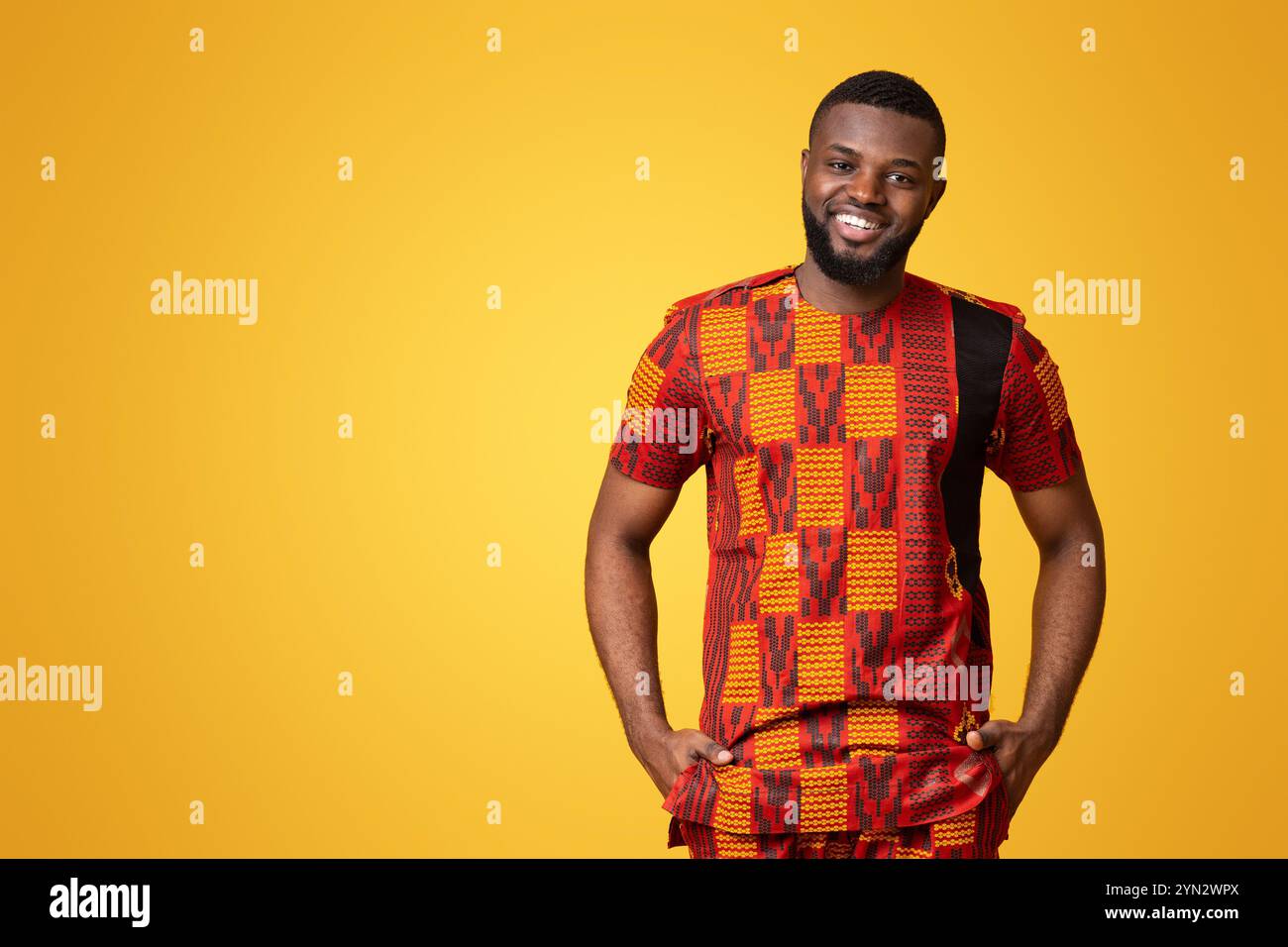 African guy in authentic clothes posing over yellow background Stock ...