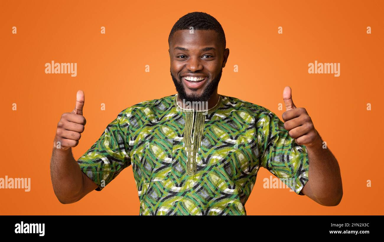 Happy black guy in green african shirt showing thumbs up Stock Photo ...