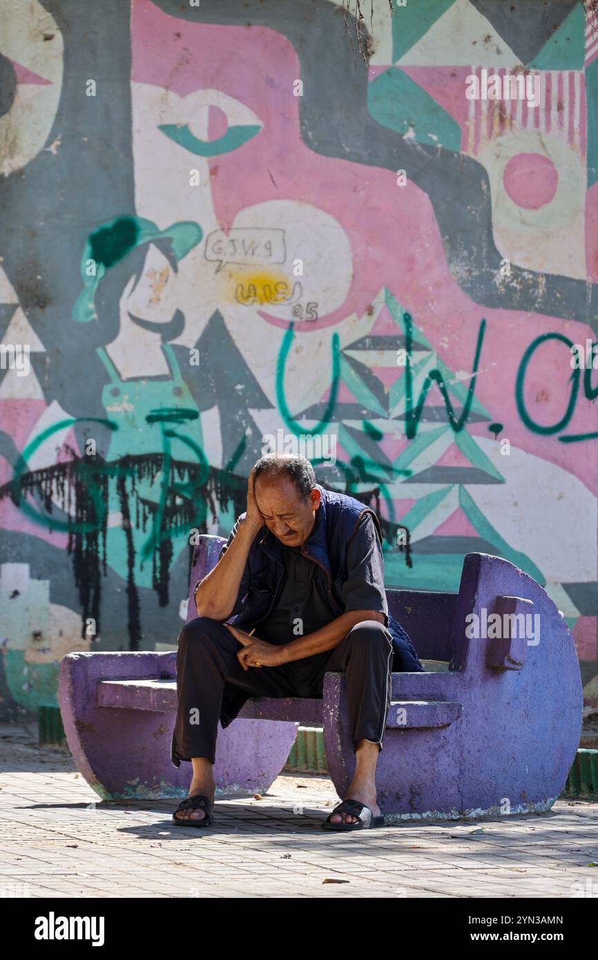 A lone man sits on a concrete bench in a public park in casablanca ...