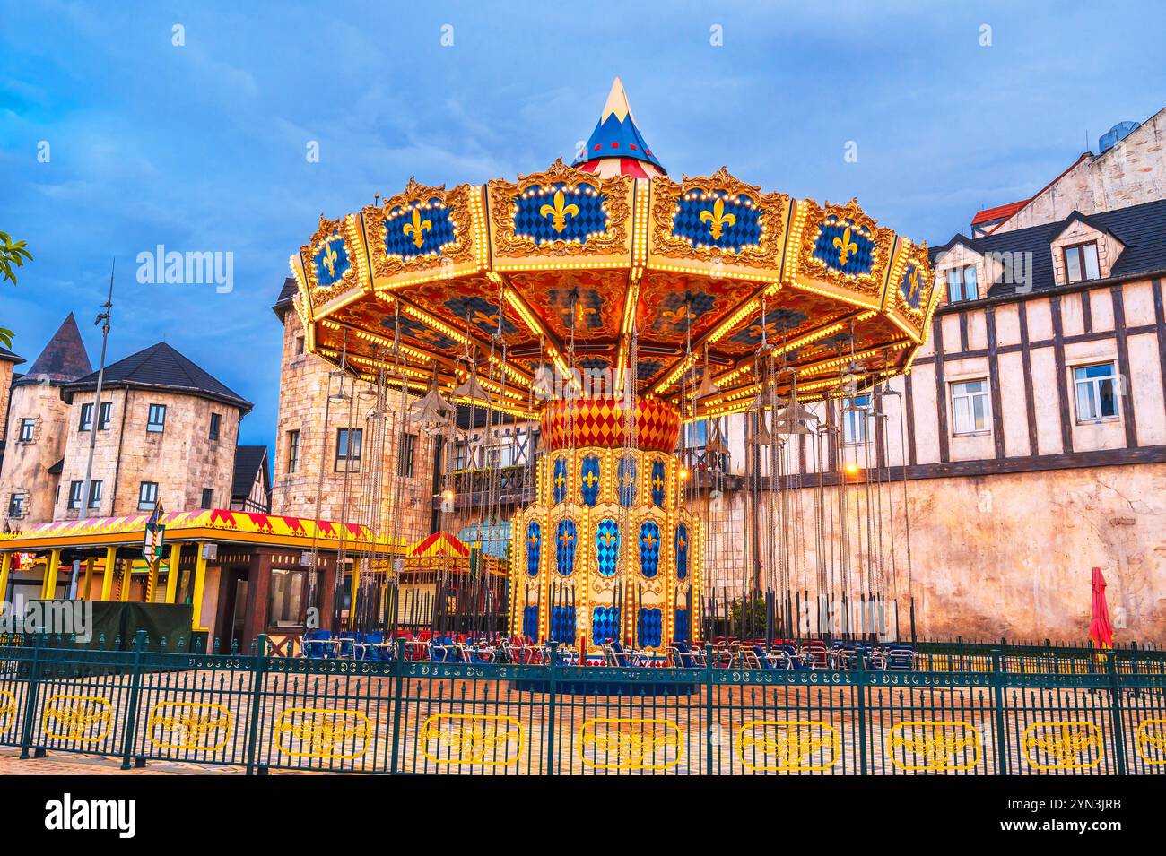 Festive chain carousel on the square of a medieval city in Europe Stock ...
