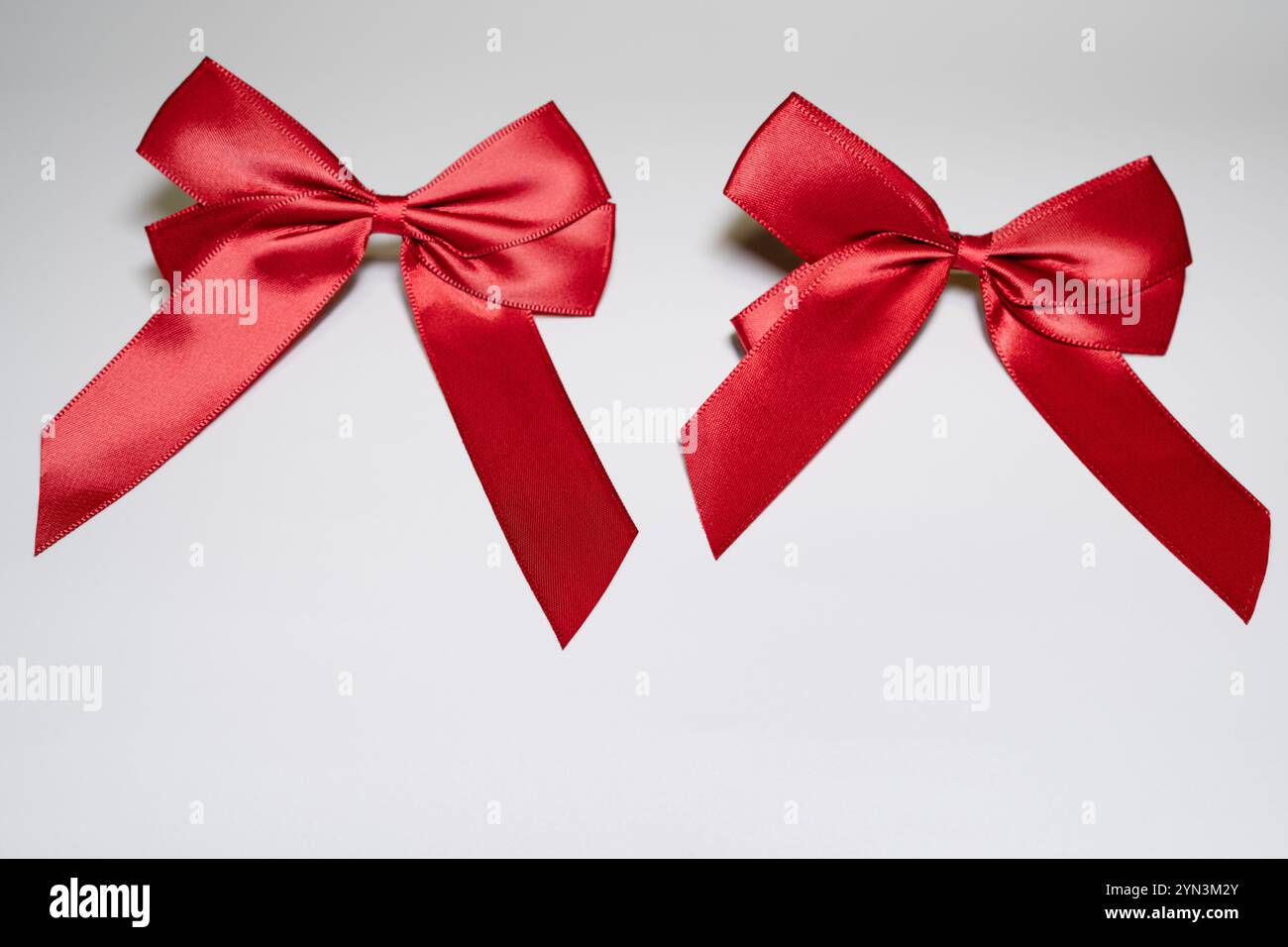 two red ribbons on a isolated white background Stock Photo - Alamy