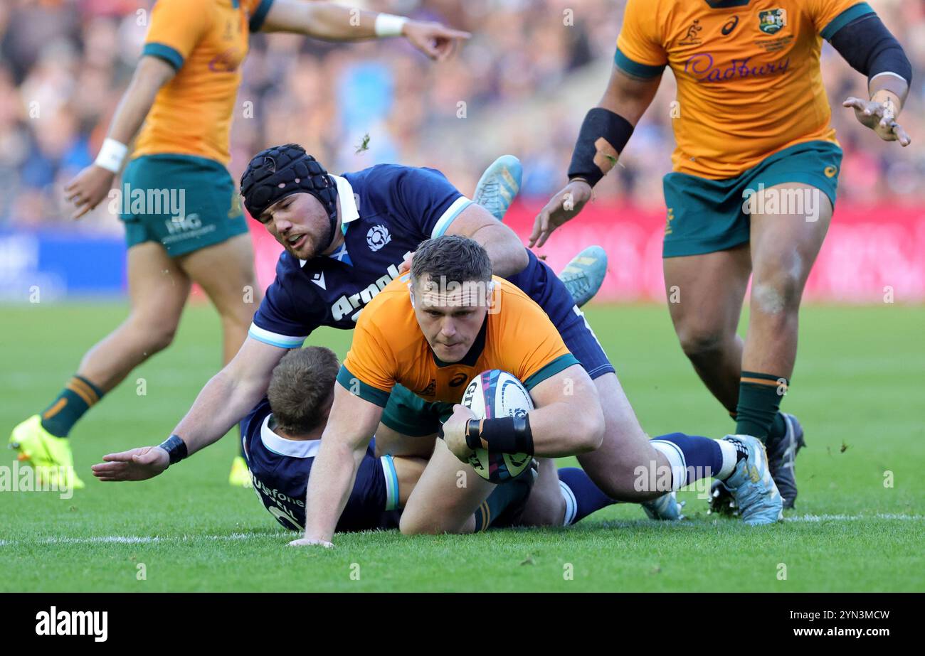 Australia's Angus Bell (centre) is tackled by Scotland's Zander ...