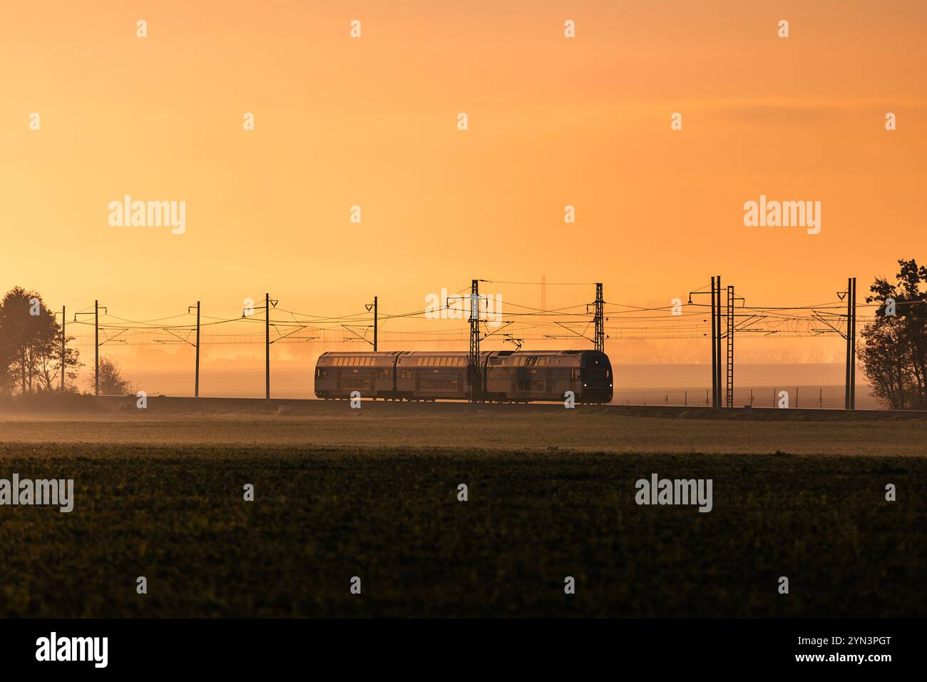 Electrified railway line at golden dawn. Modern train on railroad track ...