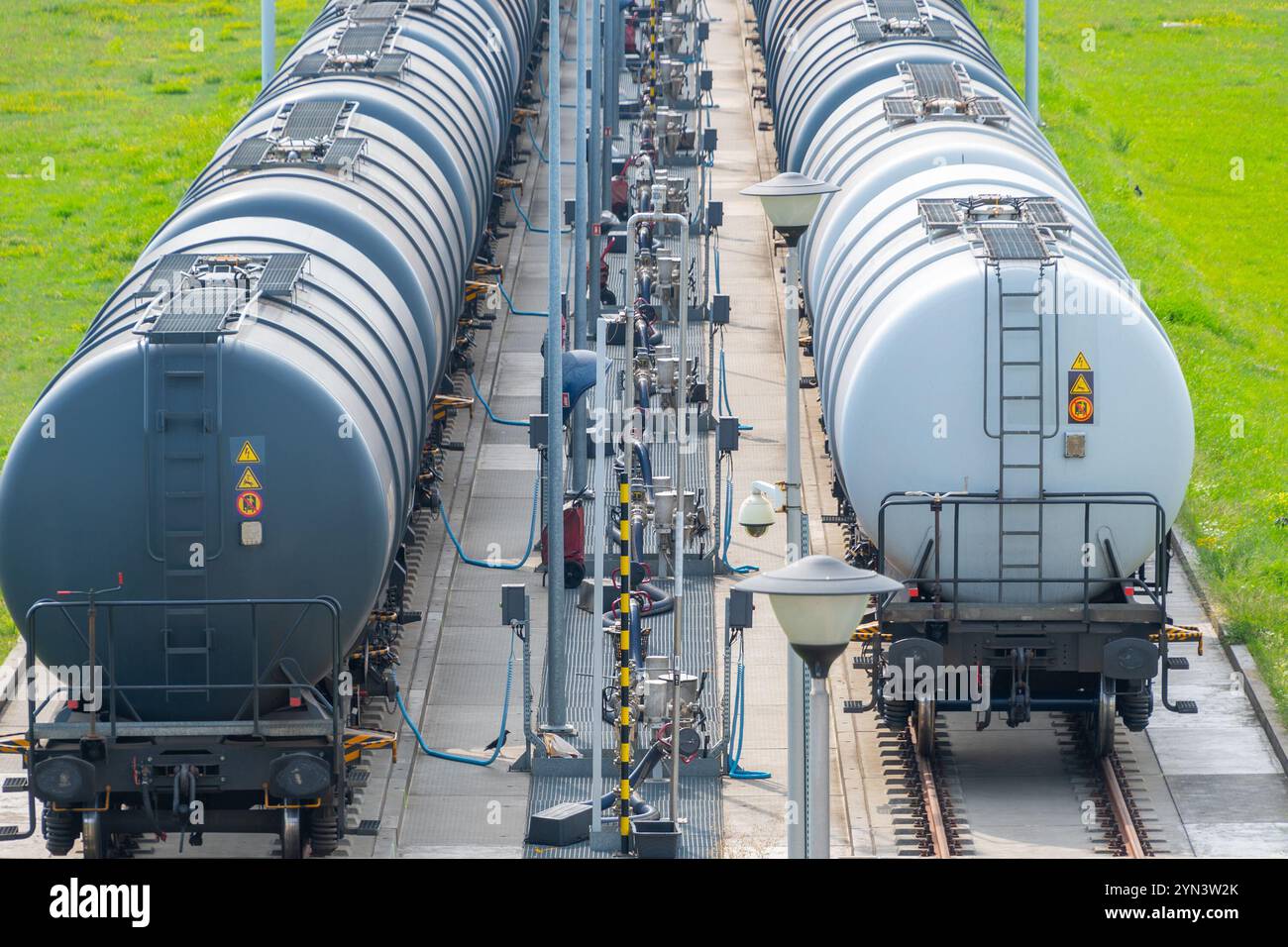 Two rows of industrial rail tank cars at a loading or fueling station ...