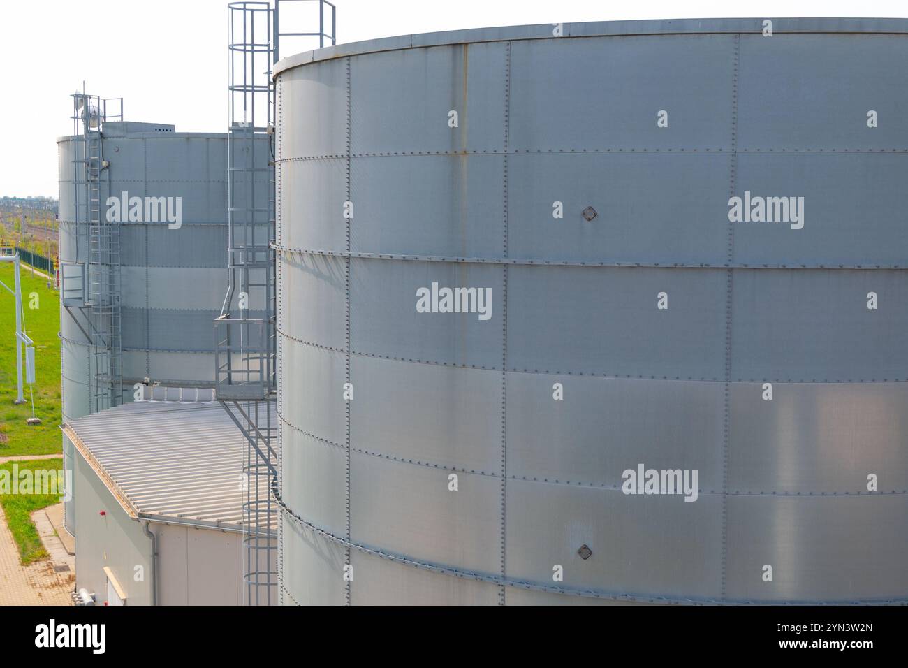 The large metallic storage tanks used for industrial purposes. The ...