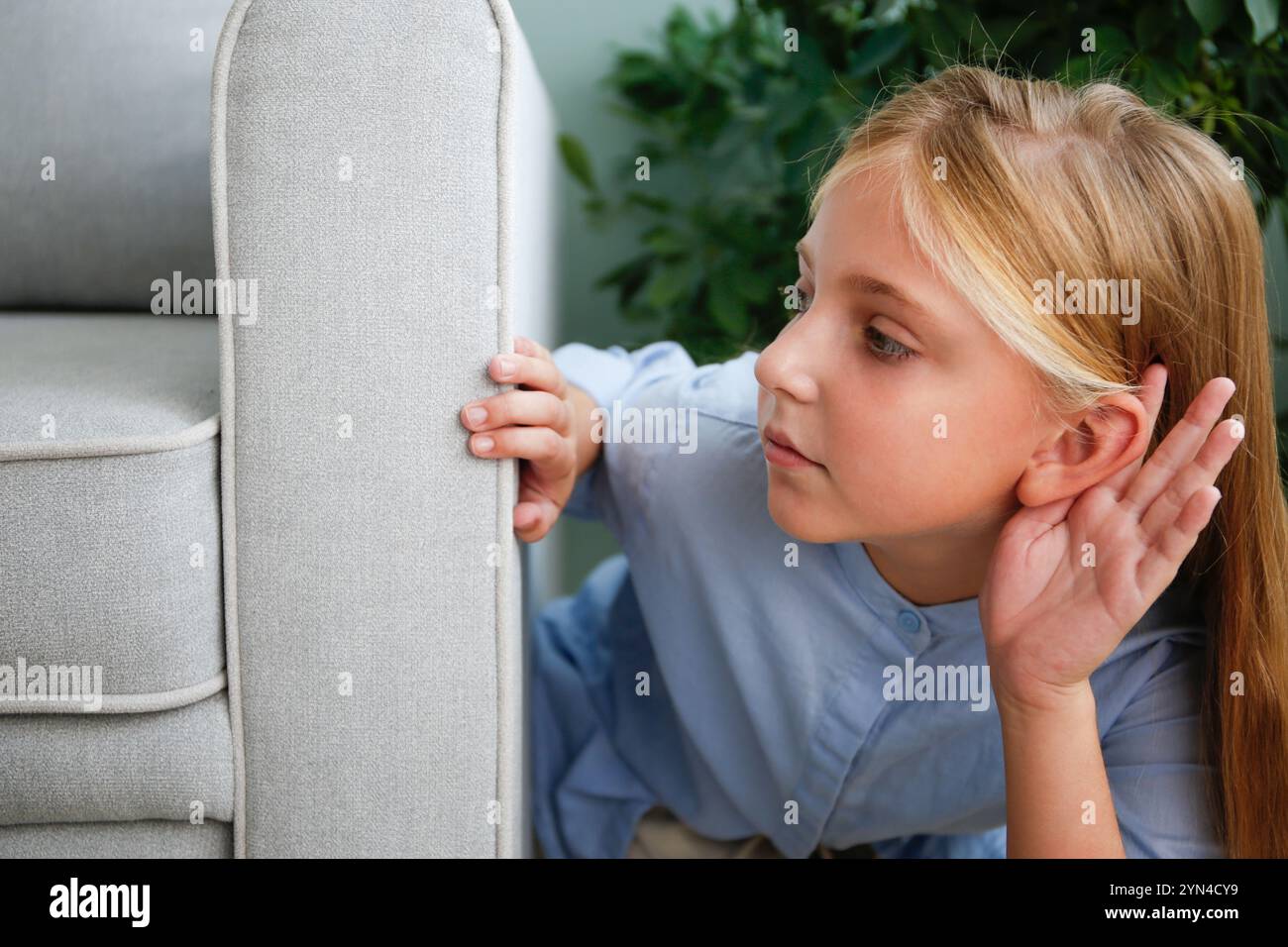 The girl is hiding behind the sofa and eavesdropping on someone else's ...