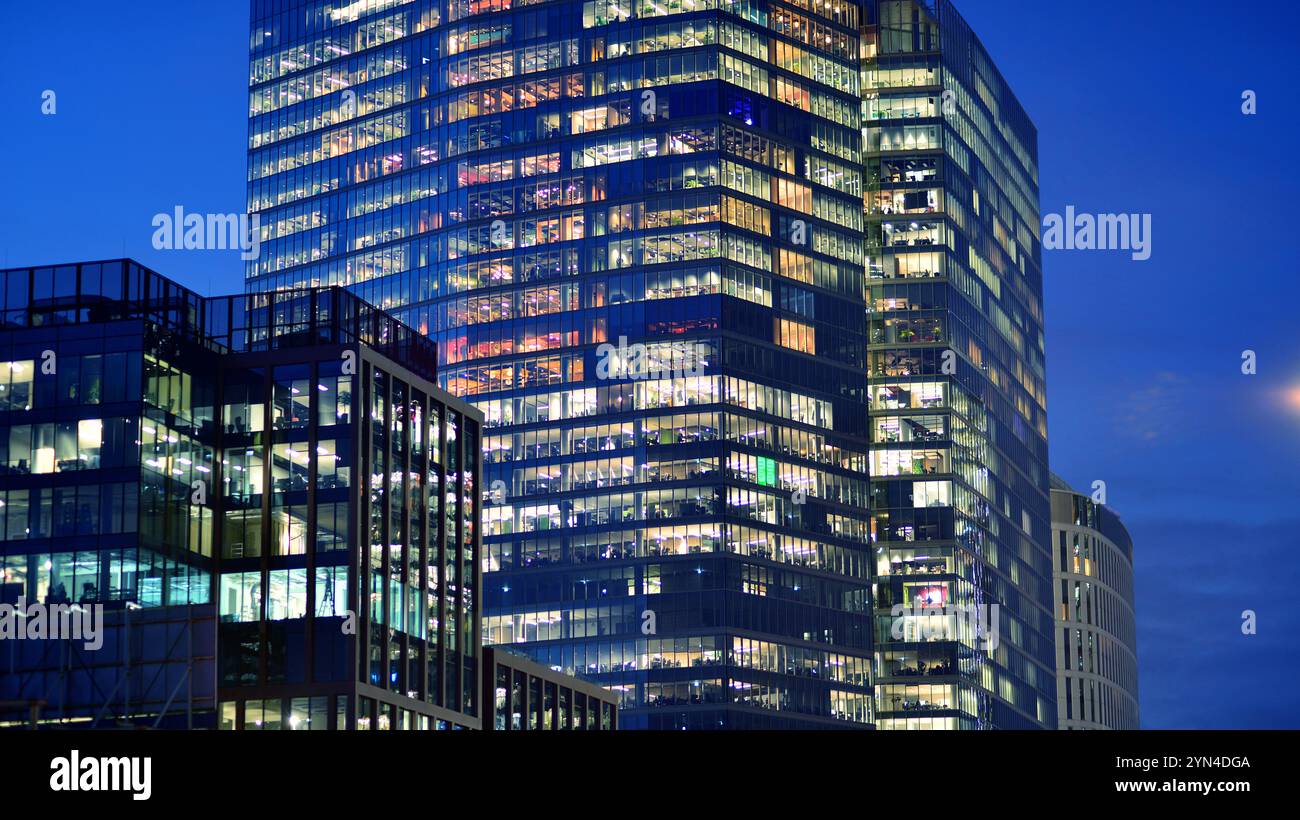 Office building in the evening with lightened workspaces. Modern ...