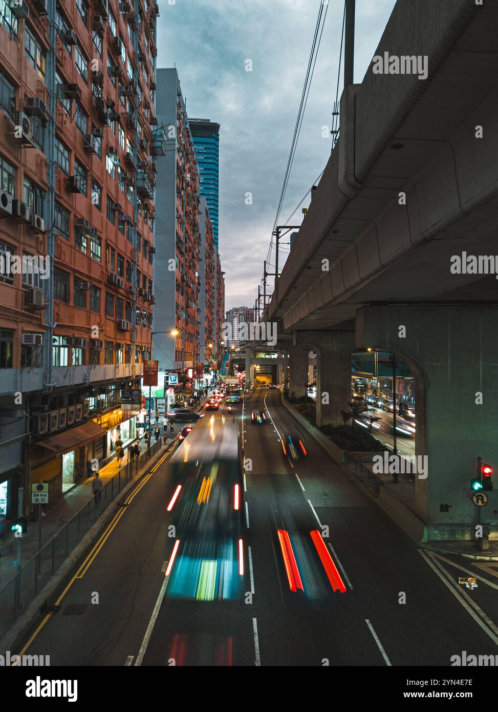 Dynamic Urban Street Scene with Motion Blur Traffic and High-Rise Buildings in Hong Kong at Dusk ...