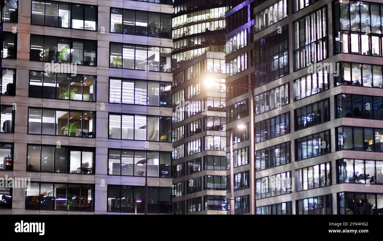 Office building in the evening with lightened workspaces. Modern ...