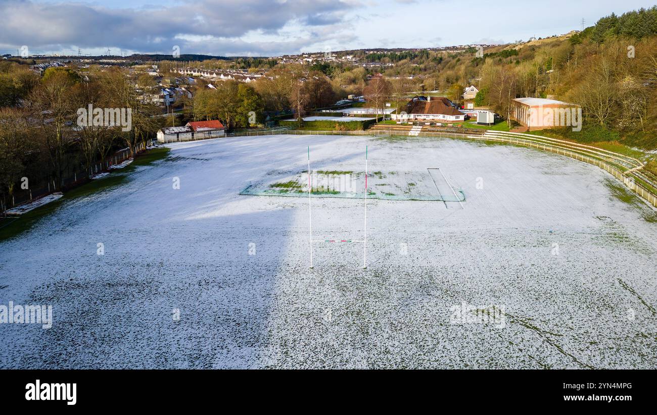 Aerial view of a rugby pitch with a covering of snow on a sunny winters ...