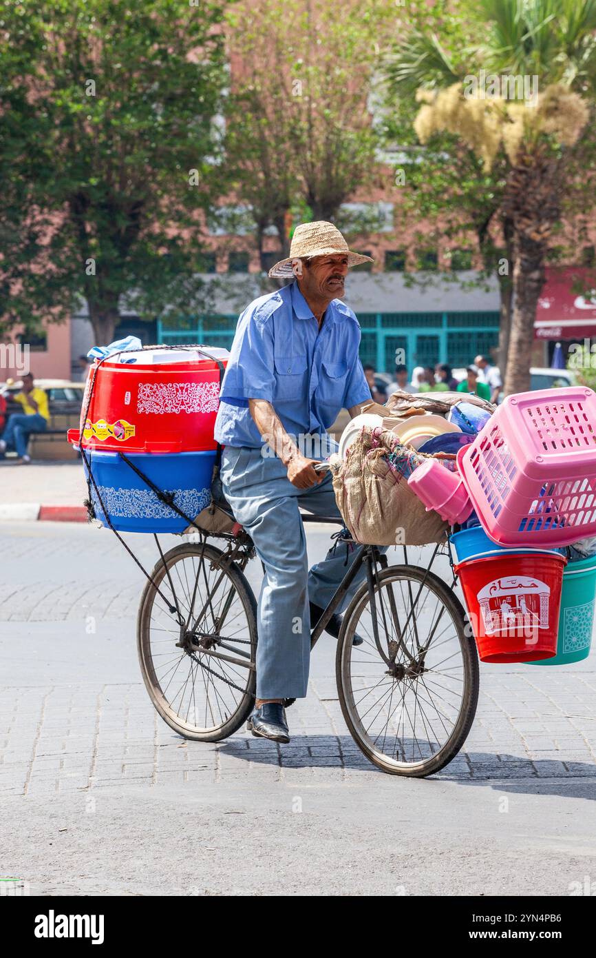 Man on bicycle carrying various plastic objects and containers Stock ...
