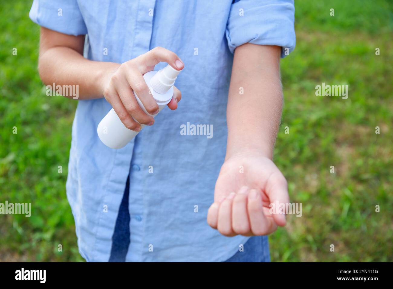 A teenager applies insect spray on his hand. The concept of prevention ...