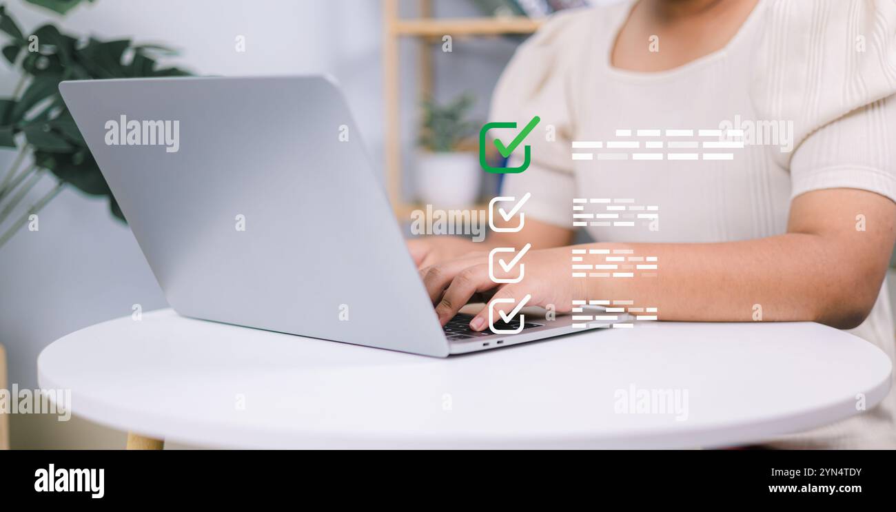 Woman working on laptop and tablet productivity checklist and filling ...