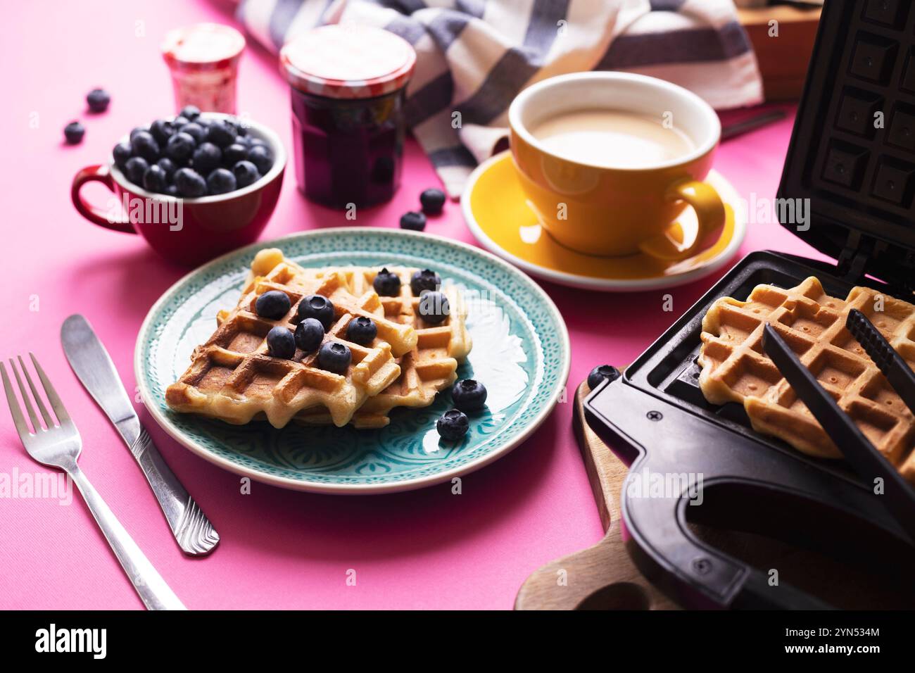 morning and bright breakfast on the pink background. belgian waffles ...