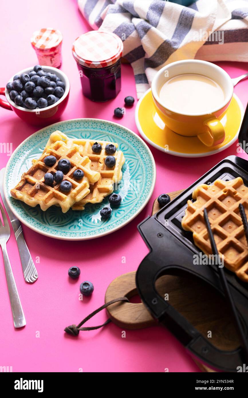 morning and bright breakfast on the pink background. belgian waffles ...