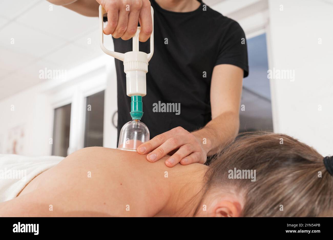 Therapist's hands performing vacuum cupping therapy treatment on female ...