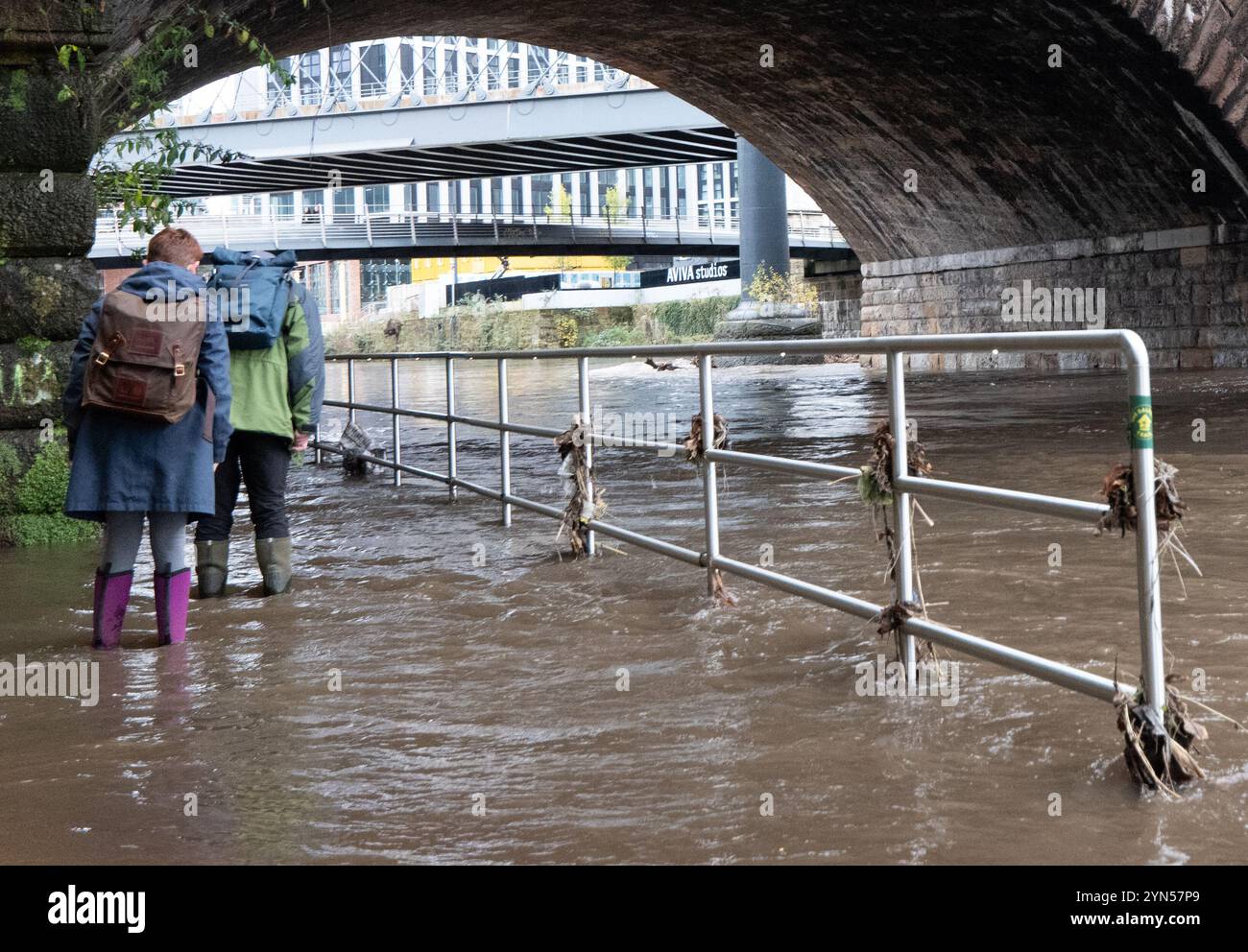 Couple attempt to wade through flood on pathway under Bridge with ...