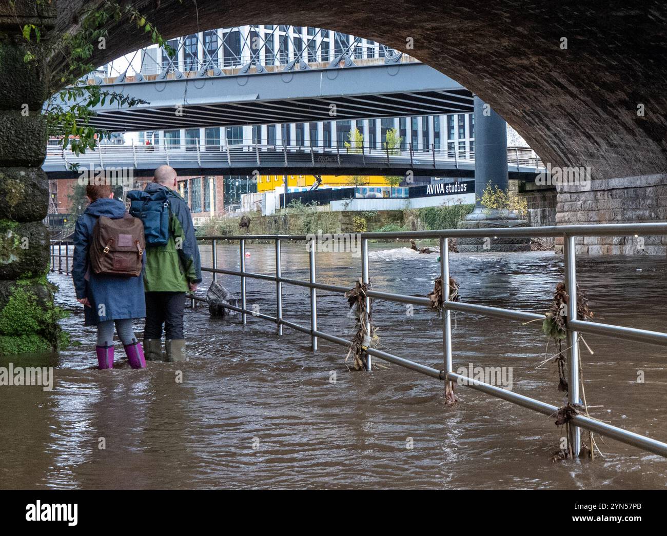 Couple attempt to wade through flood on pathway under Bridge with ...