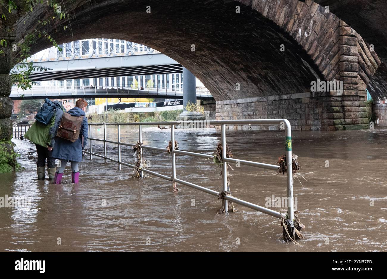 Couple attempt to wade through flood on pathway under Bridge with ...