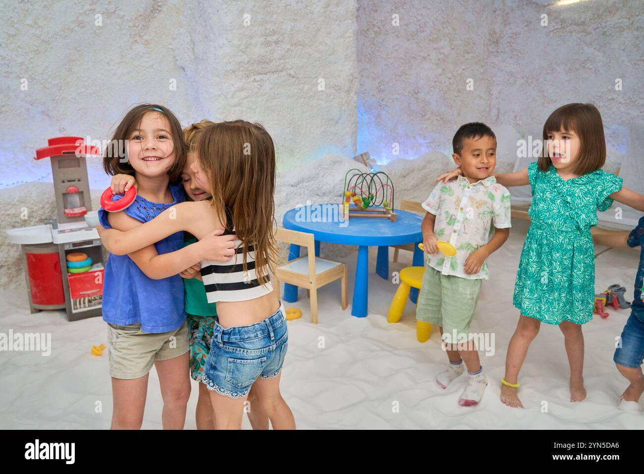 Group of children hugging and playing in a salt cave during halotherapy ...