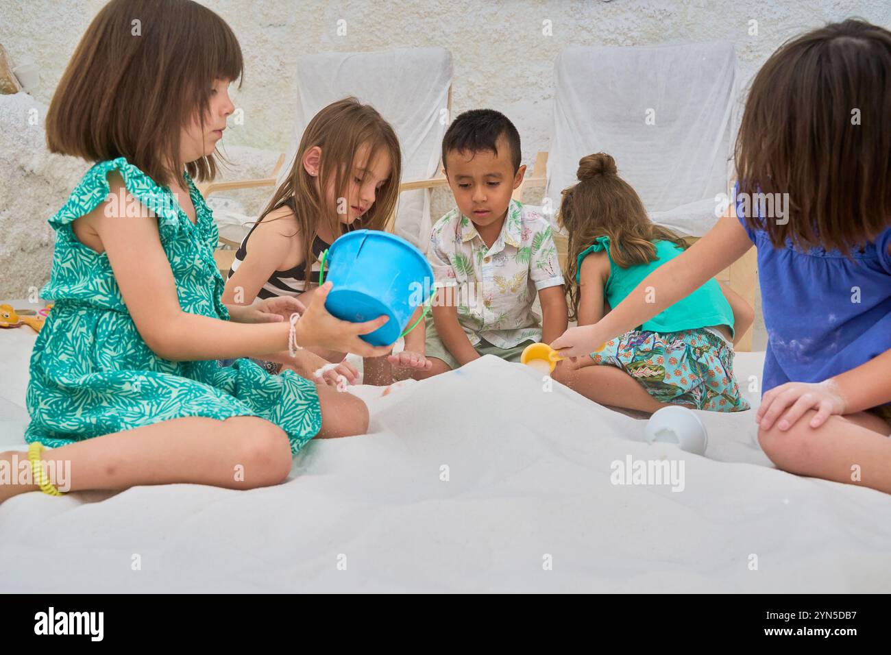 Children playing with buckets and sand in a salt cave during ...