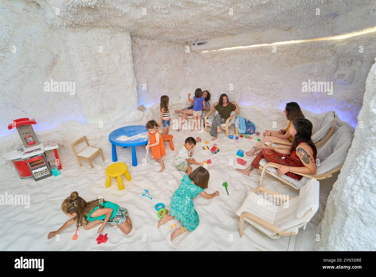 Children playing in a salt therapy room while adults relax Stock Photo ...