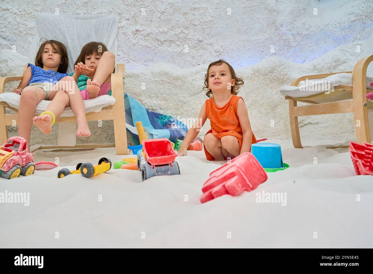 Children playing with toys in a sand-filled playroom Stock Photo - Alamy